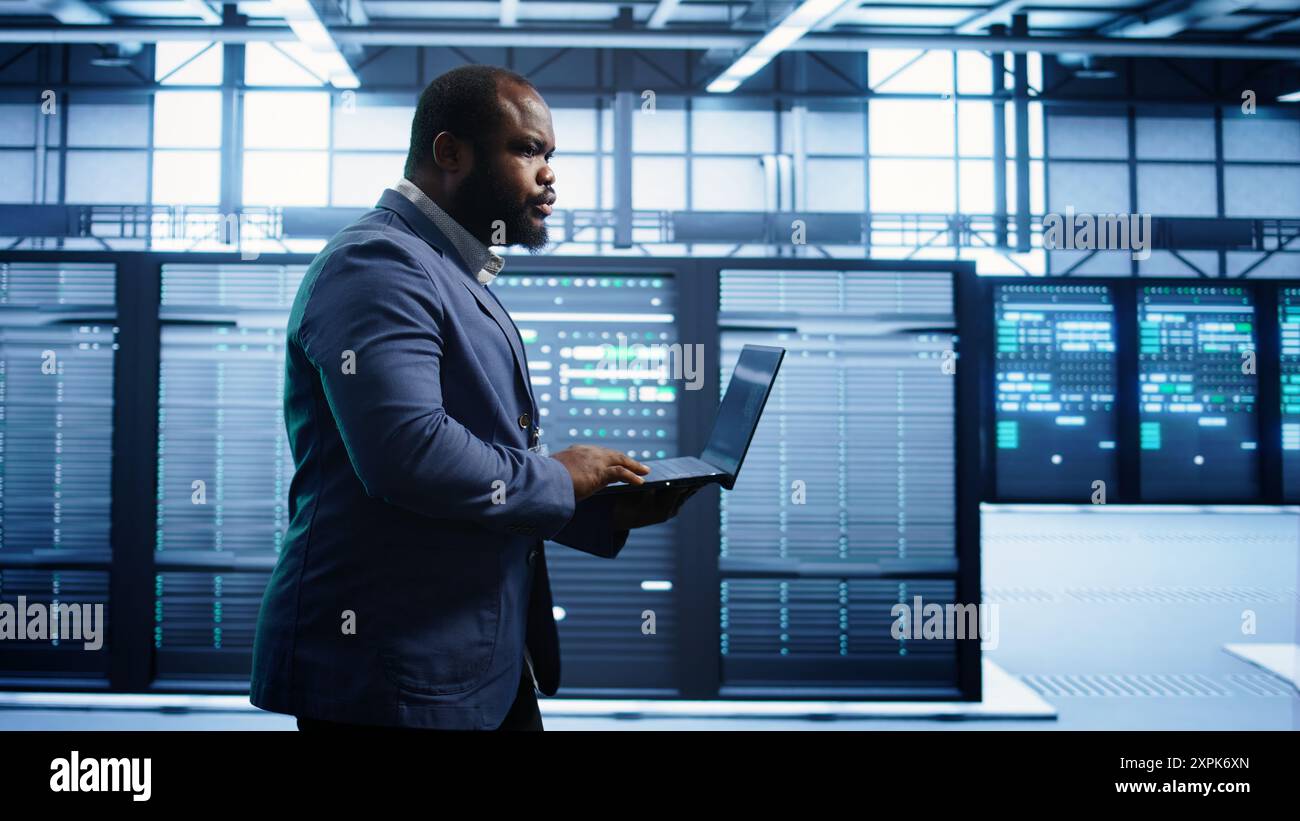 Admin doing yearly checkup using notebook to prolong data center electronics life span and avoid ...