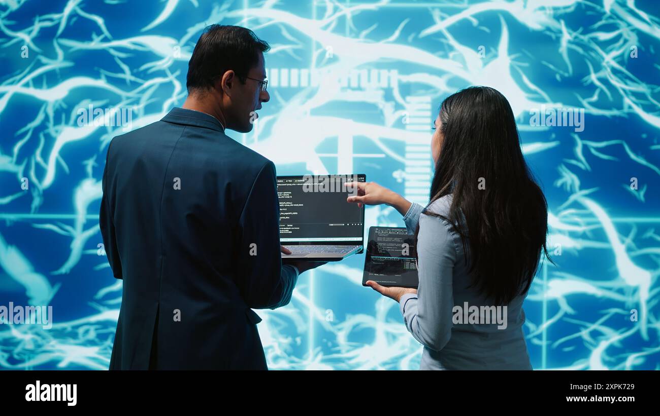 Coworkers doing brainstorming, using devices to fix artificial ...