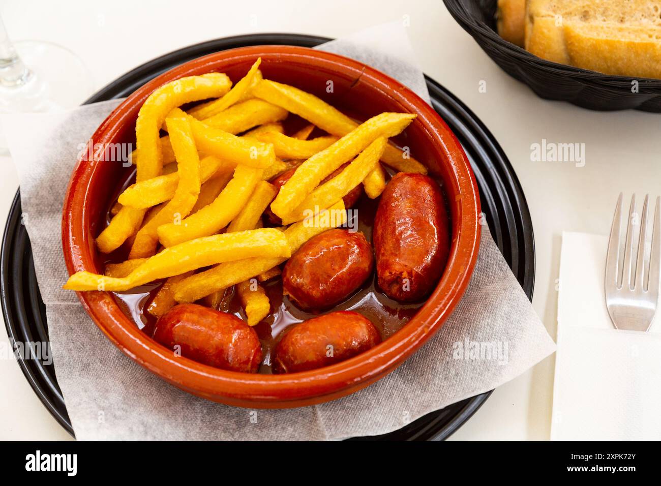 Chorizo with cider served with French fries Stock Photo - Alamy