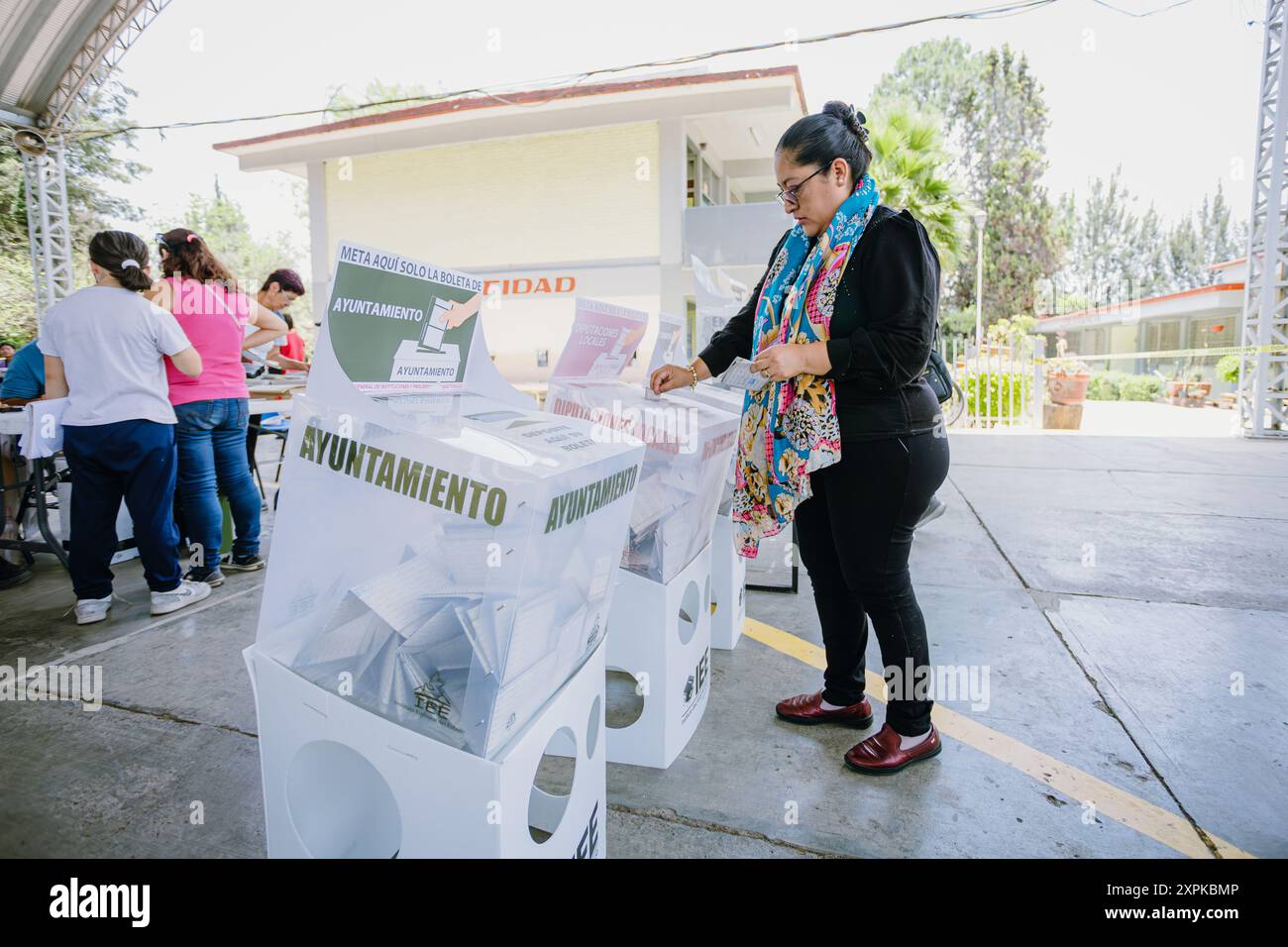 A person places their ballot into the box at an electoral station set ...