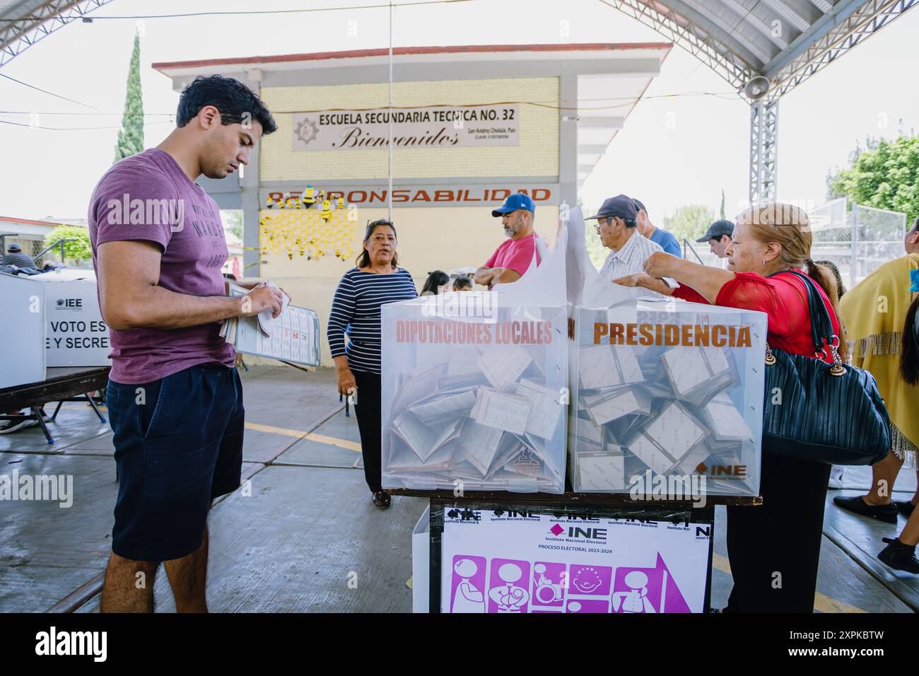 A person places their ballot into the box at an electoral station set ...