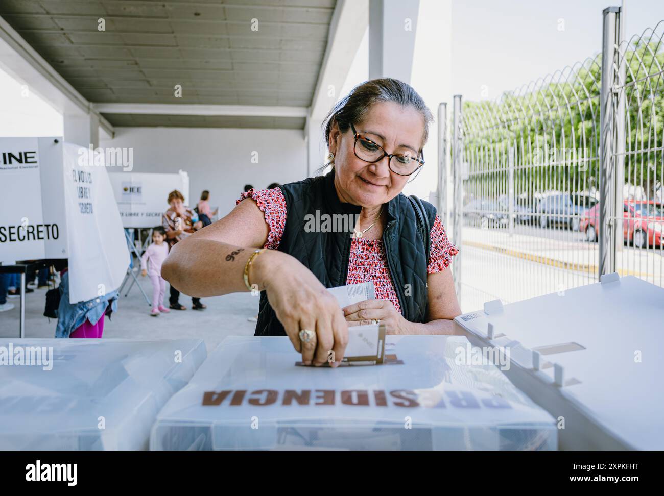 A person places their ballot into the box at an electoral station set ...