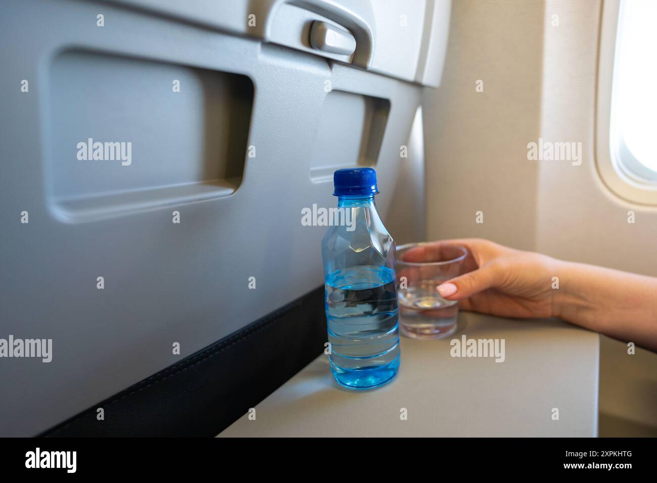 Woman holding plastic glass of water on the aircraft for drinking ...