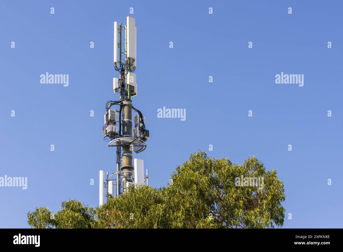 Modern cellular tower with antennas and equipment, standing tall above ...