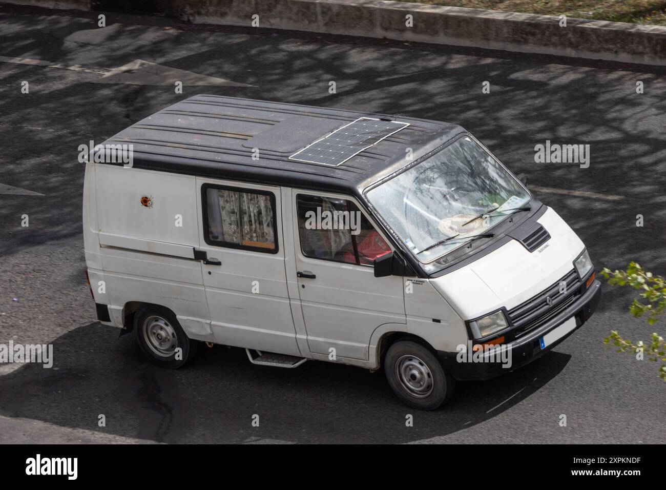 White renault trafic van with a solar panel on the roof driving on a ...