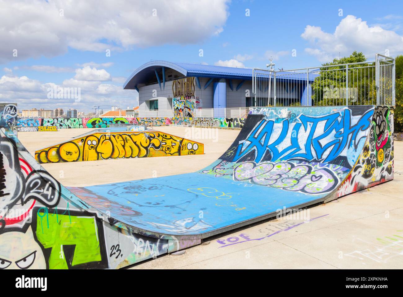Skate ramps covered with colorful graffiti art are standing in an empty ...