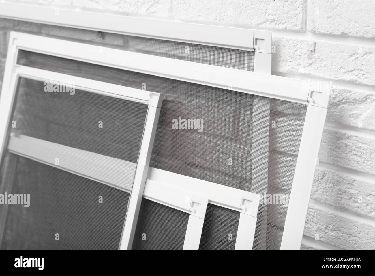 Set of window screens near white brick wall, closeup Stock Photo - Alamy