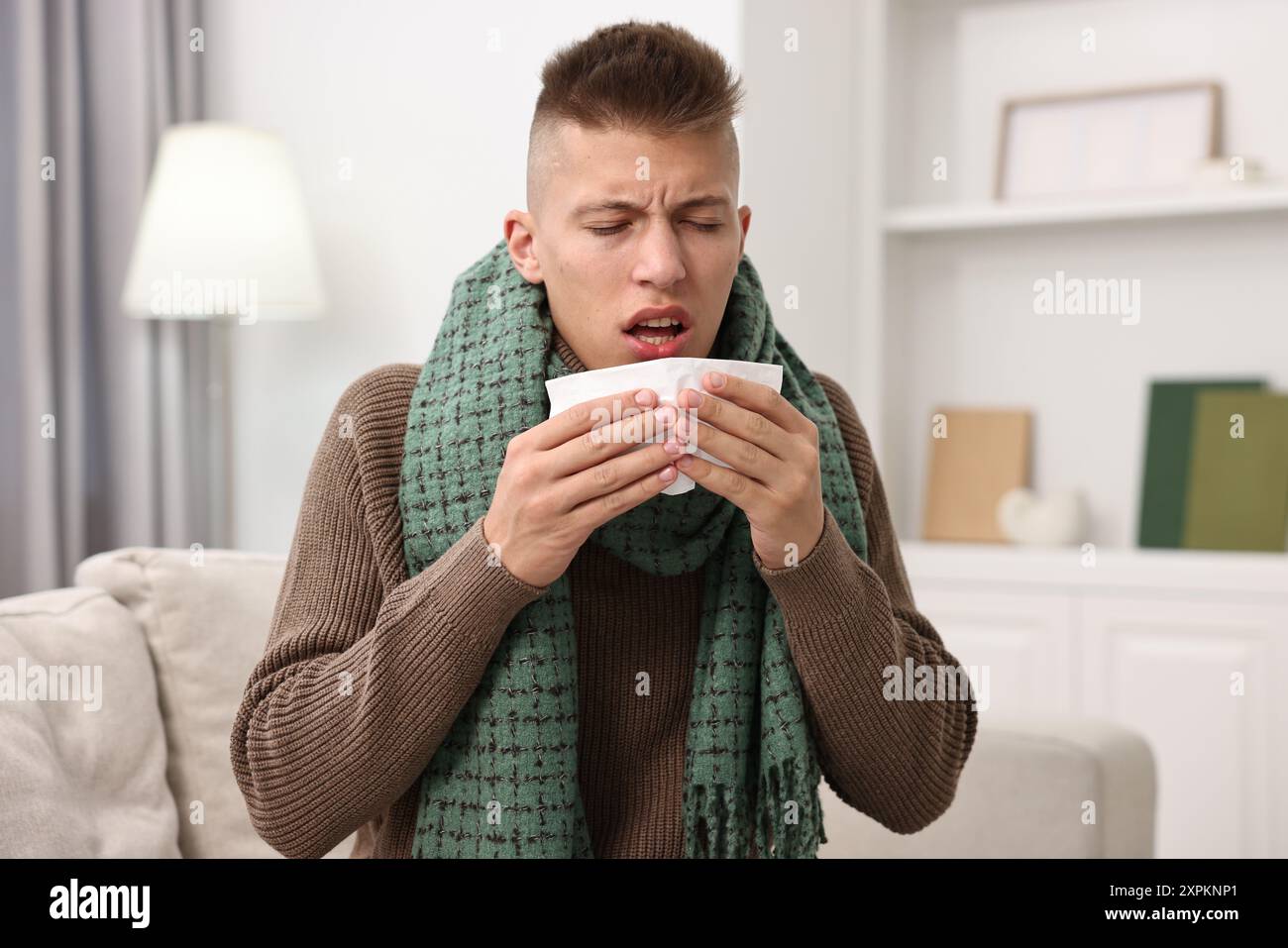 Cold symptom. Young man with runny nose at home Stock Photo - Alamy