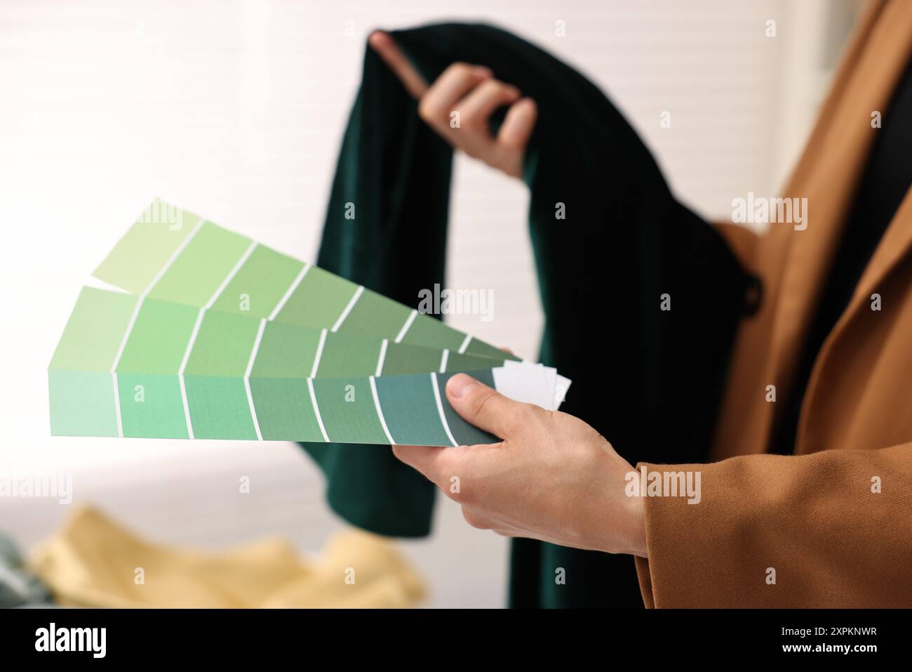 Fashion designer with color palettes and fabric in workshop, closeup ...