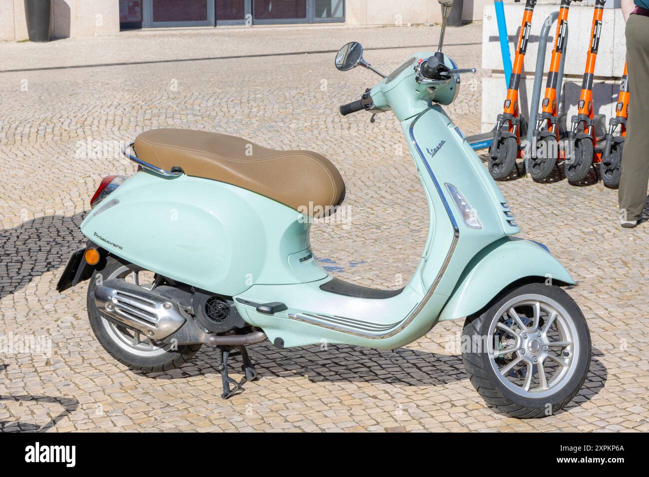 Classic mint green scooter with a brown leather seat standing on a ...