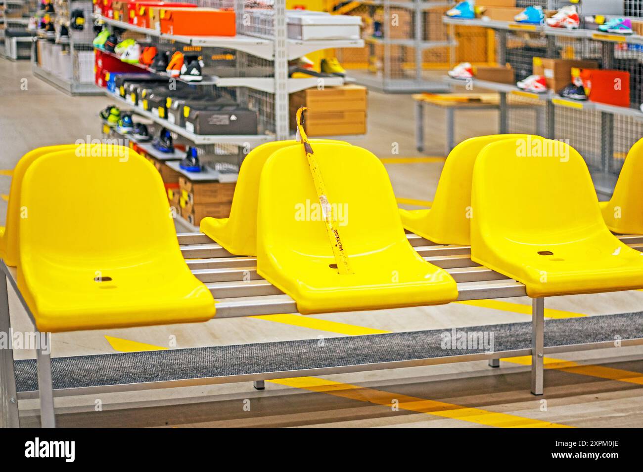 yellow stylish seats for putting on shoes in the shoe department of the ...
