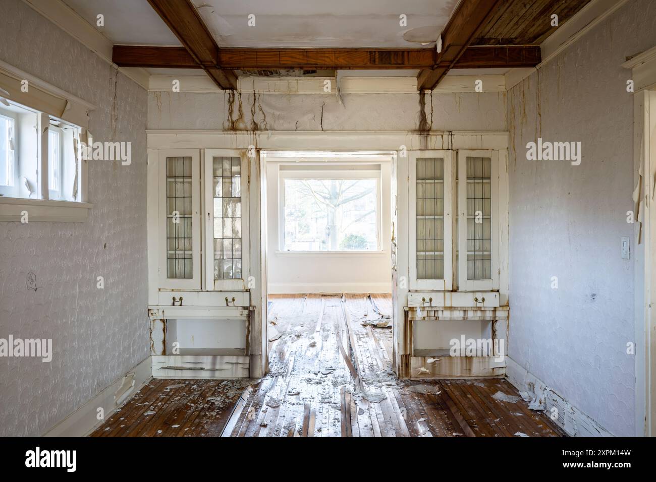 A doorway leading into another room and a water damaged floor. This ...