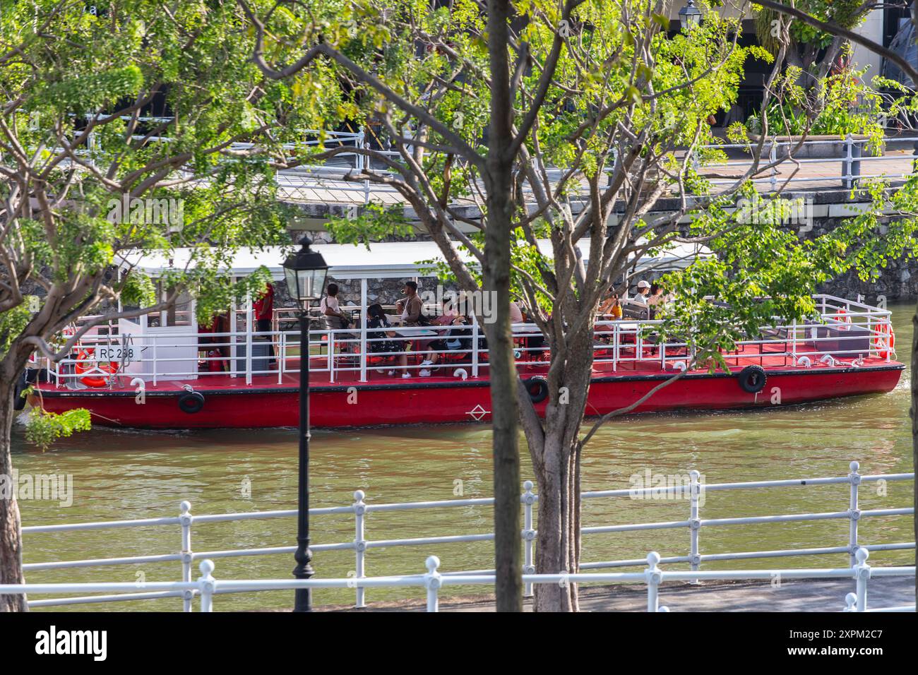 Visitors sit inside a river boat cruise along Singapore river enjoying ...