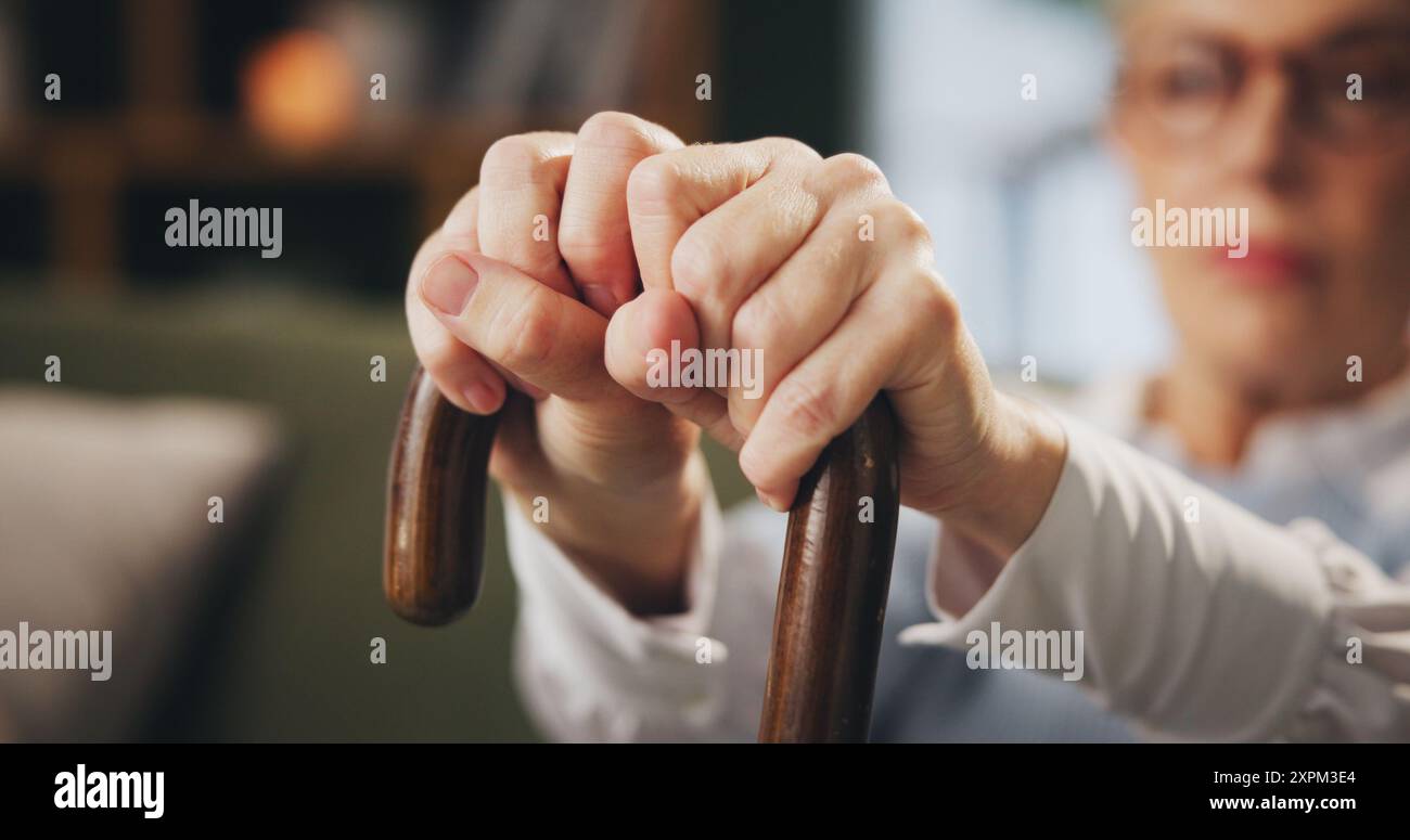 Walking stick, hands and senior woman with disability at home ...