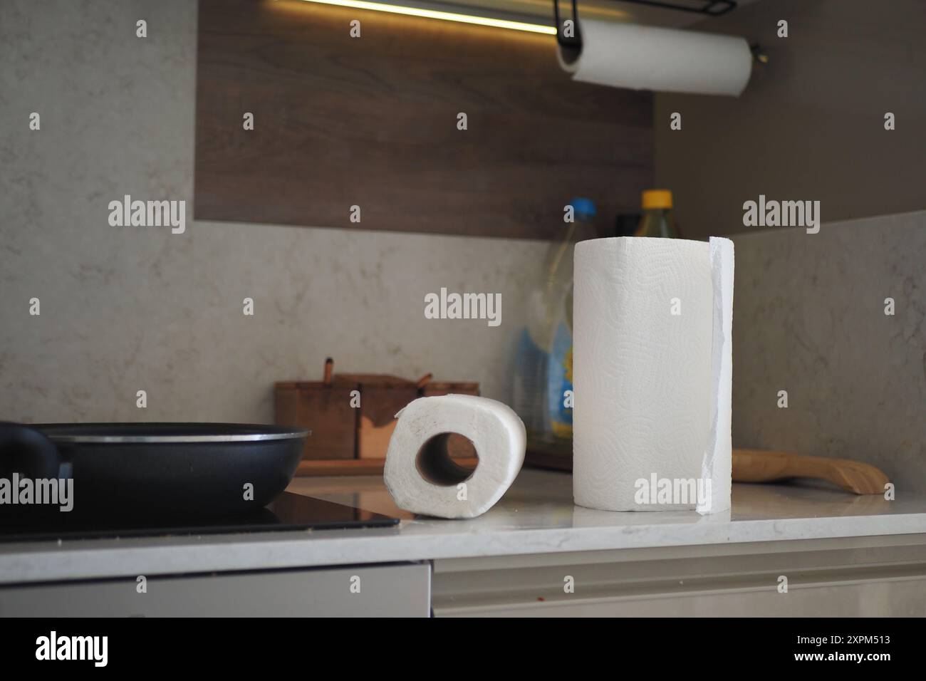 A kitchen counter featuring a paper towel roll alongside various ...