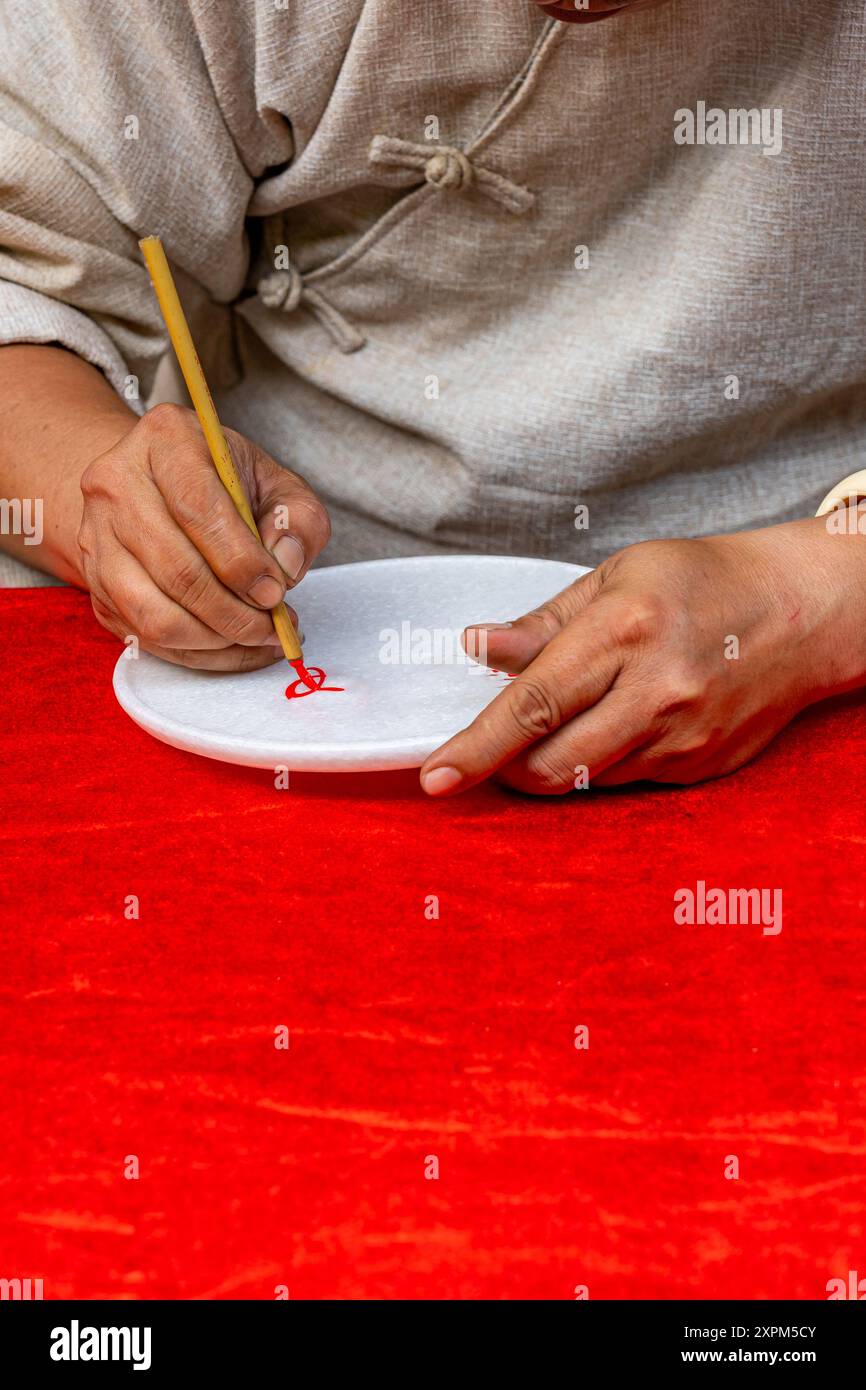 Vertical photo of human hand doing handwriting by calligraphic brush ...