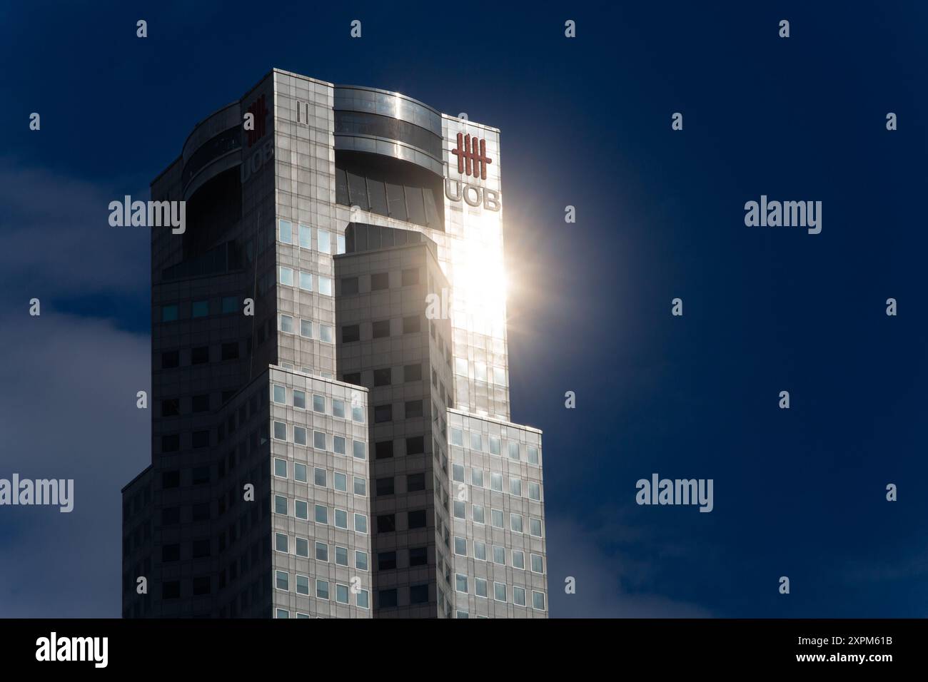 Top levels of UOB plaza skyscraper building reflects strong lighting ...