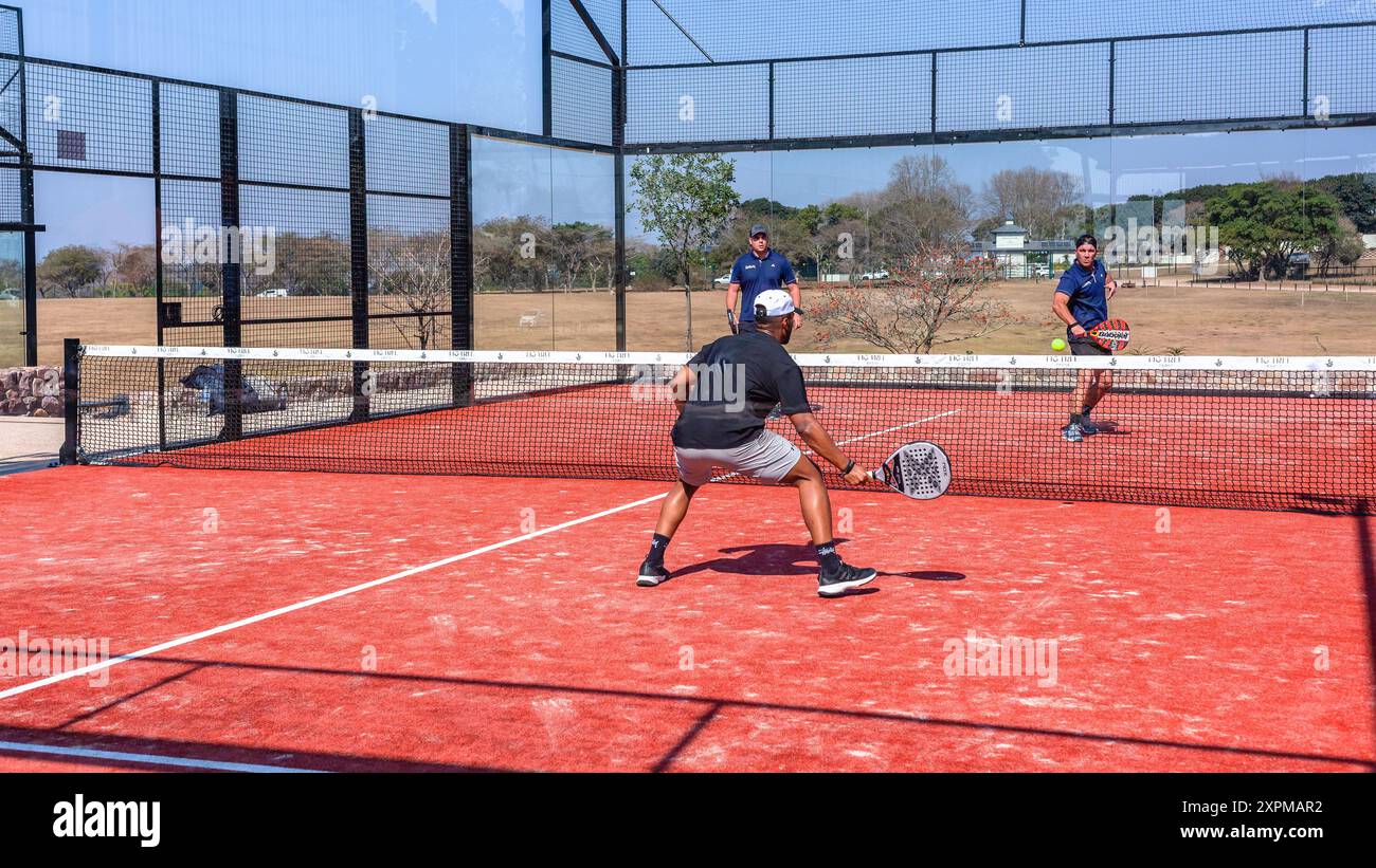 Padel Tennis game action team doubles players on outdoor red astro ...