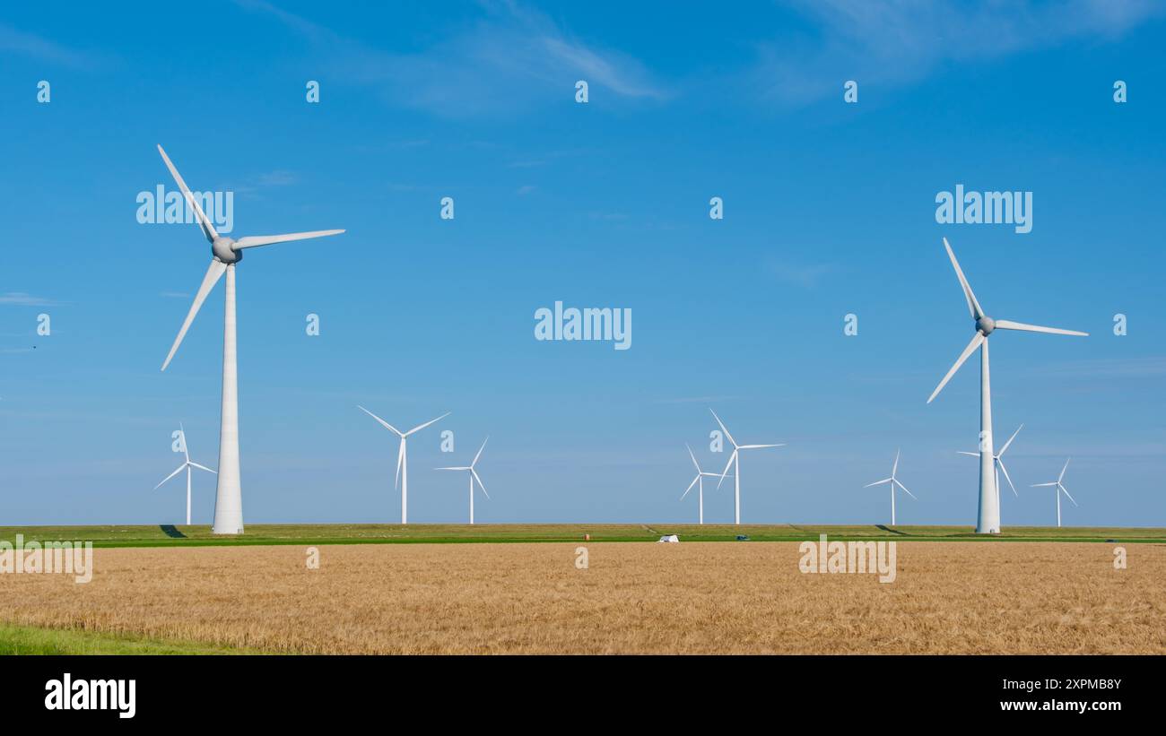 Tall windmill turbines spin gracefully under a clear blue sky ...