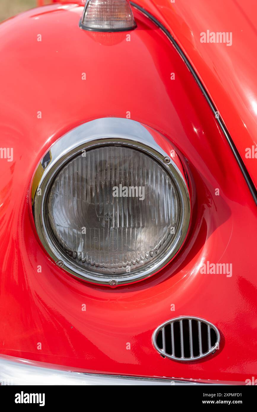 Front headlight on a bright red Volkswagen Beetle car. August 2024 ...