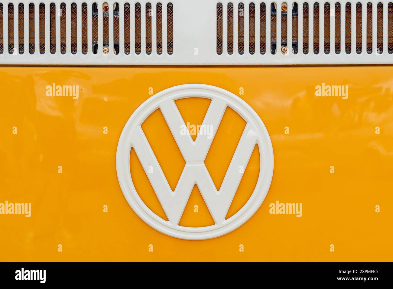 Symmetrical front view of a yellow VW camper van with company logo ...