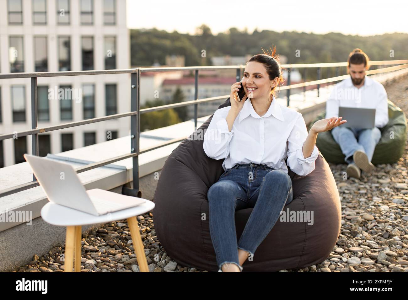 Business professionals working remotely on outdoor rooftop lounge Stock ...