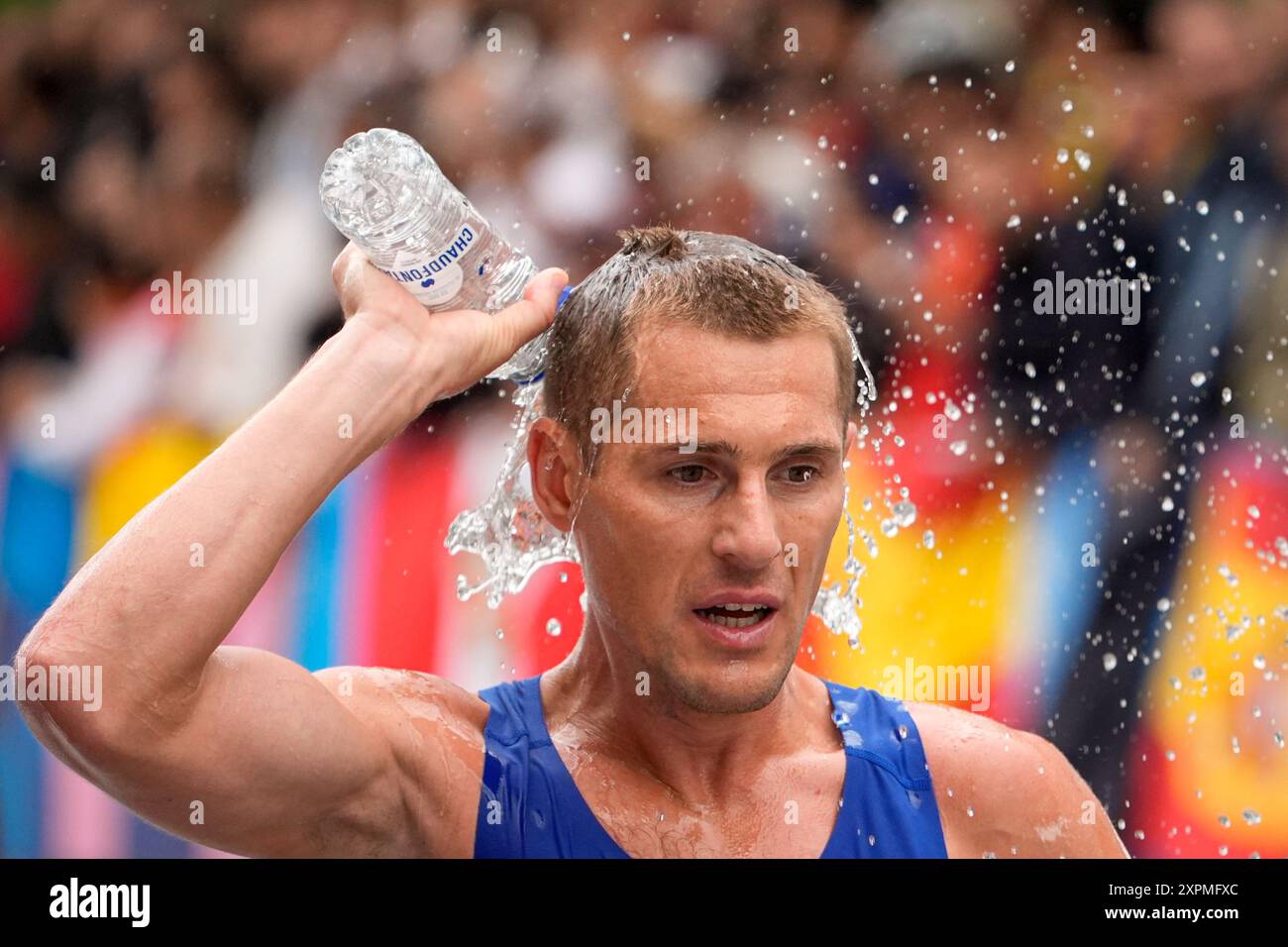 Ukraine's Ivan Banzeruk splashes himself with a bottle of water to cool down during the marathon ...