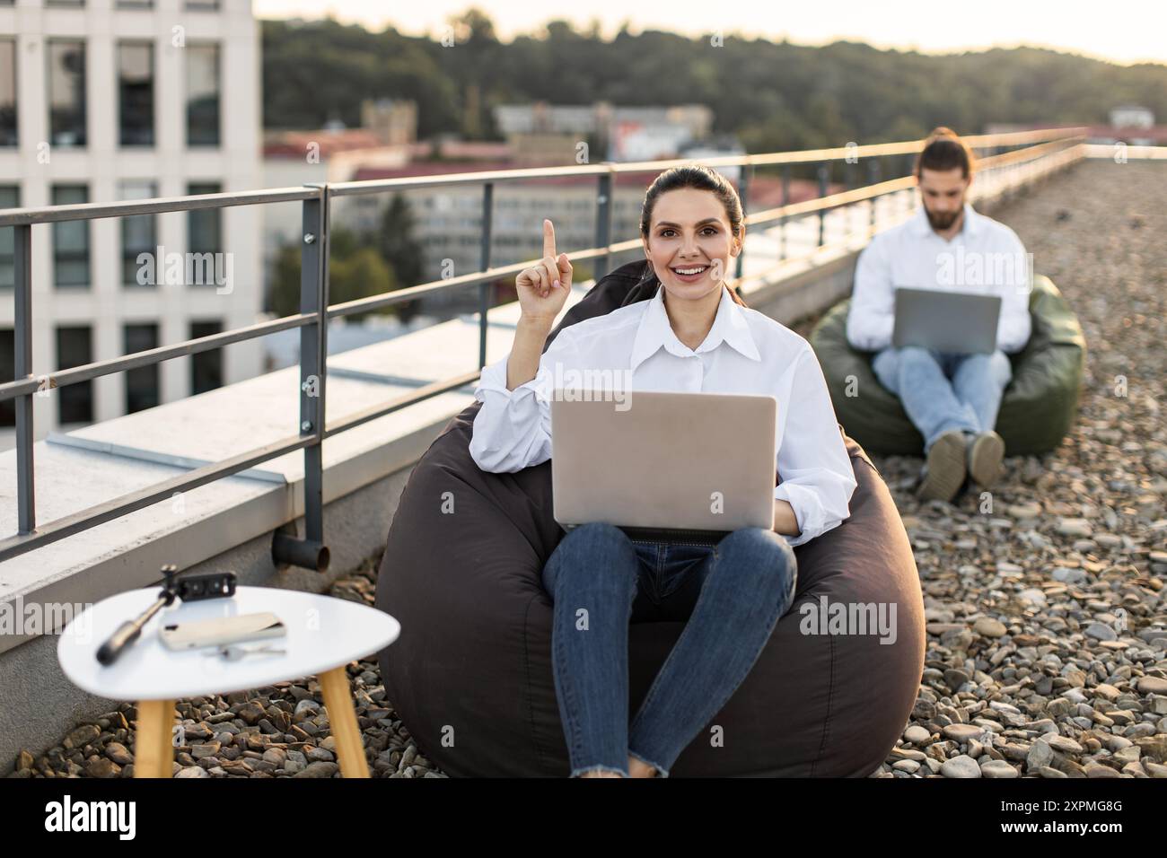 Remote work on rooftop with laptops in bean bags Stock Photo - Alamy