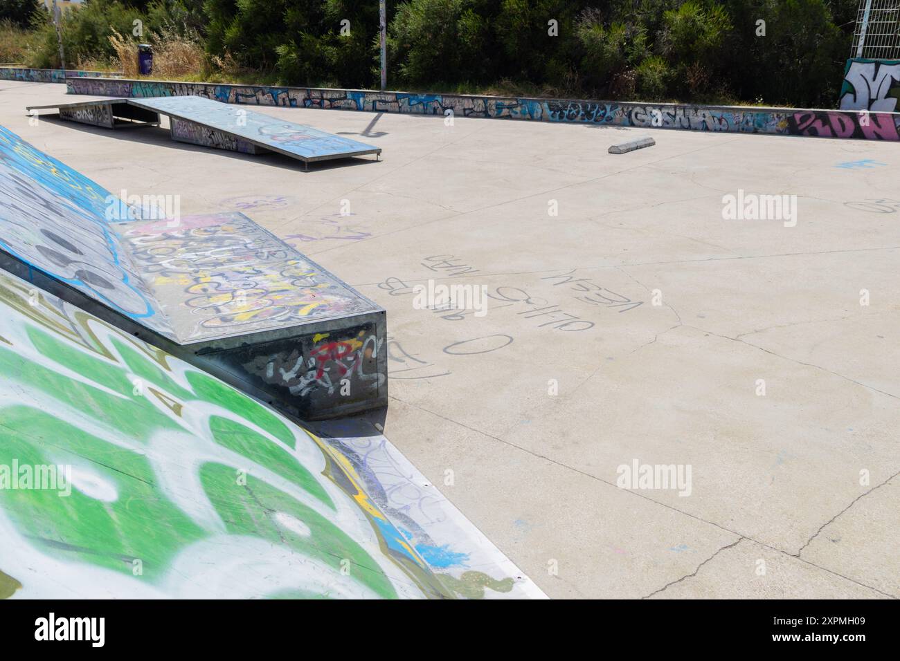 Concrete skate park with ramps and rails covered in graffiti tags Stock ...