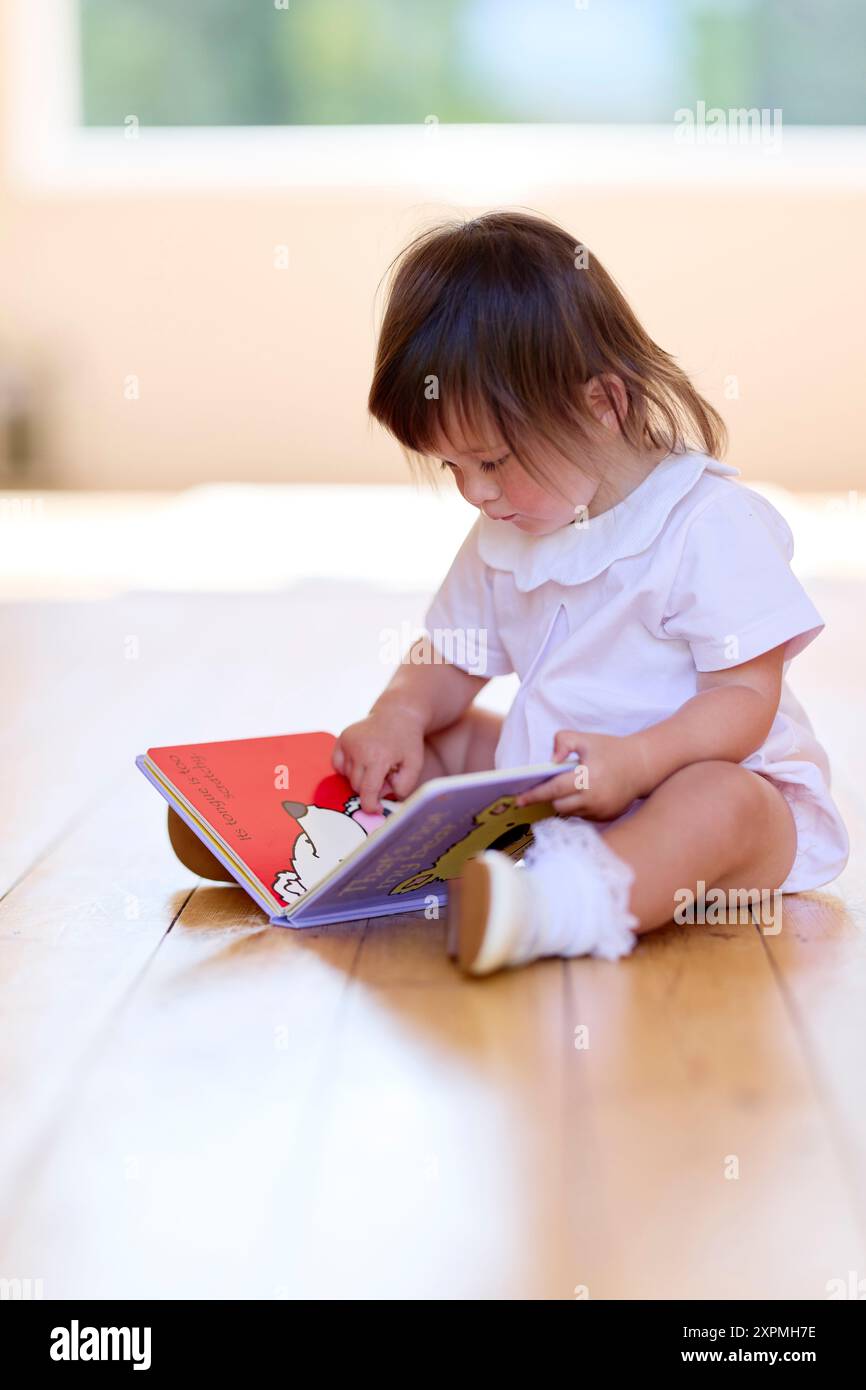 Your child sat reading a book Stock Photo - Alamy