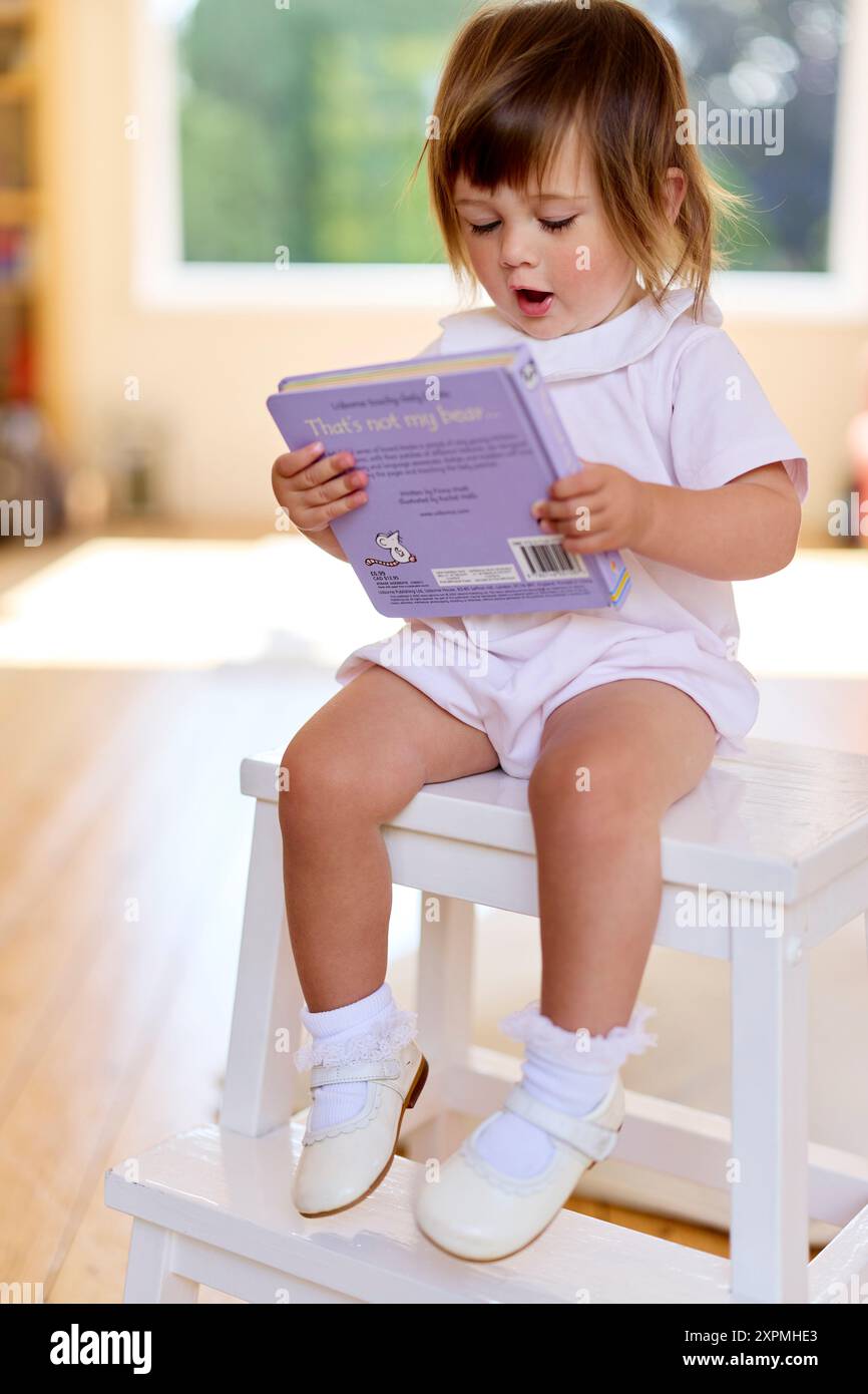 Your child sat reading a book Stock Photo - Alamy
