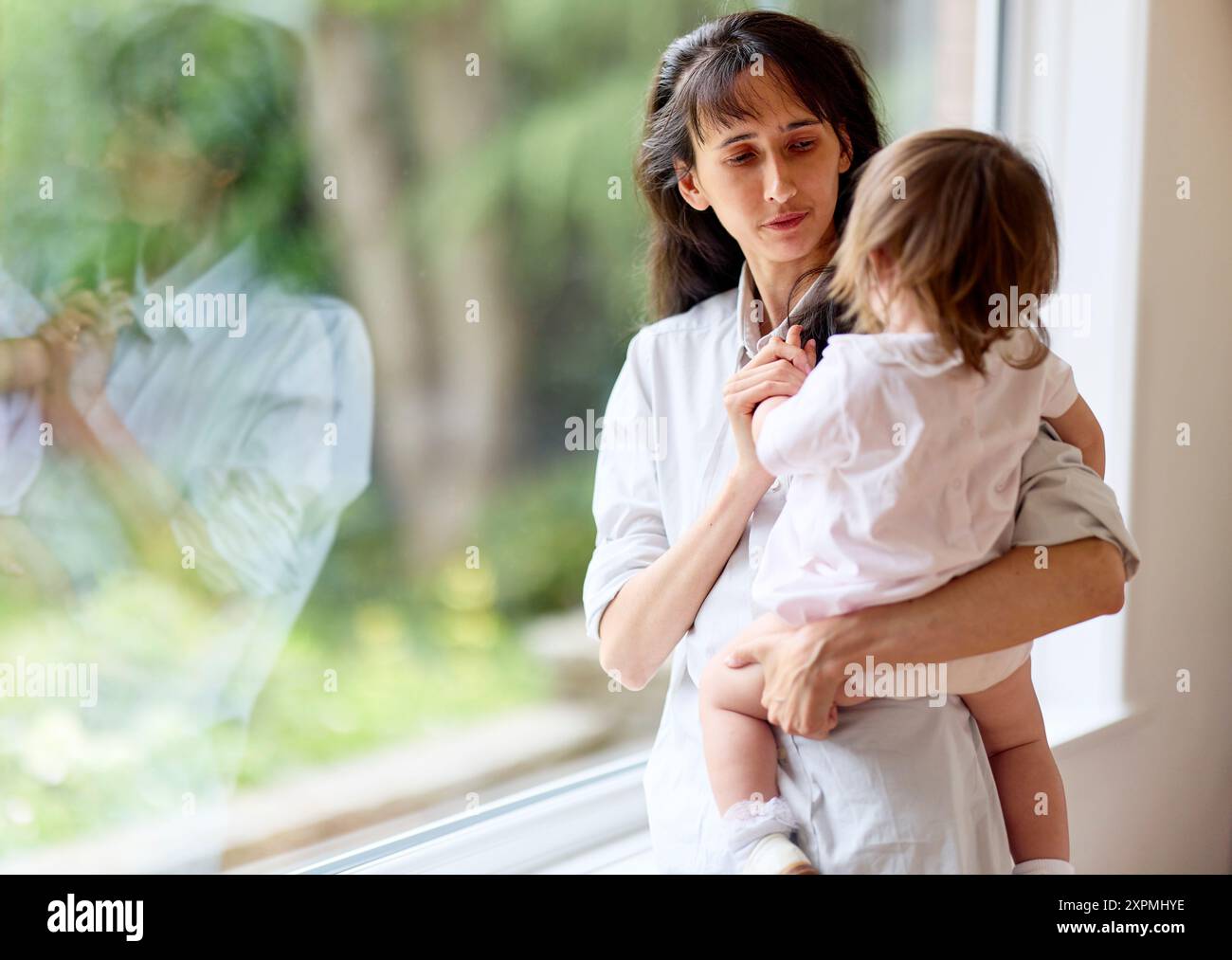 Mother and child stood at window Stock Photo - Alamy