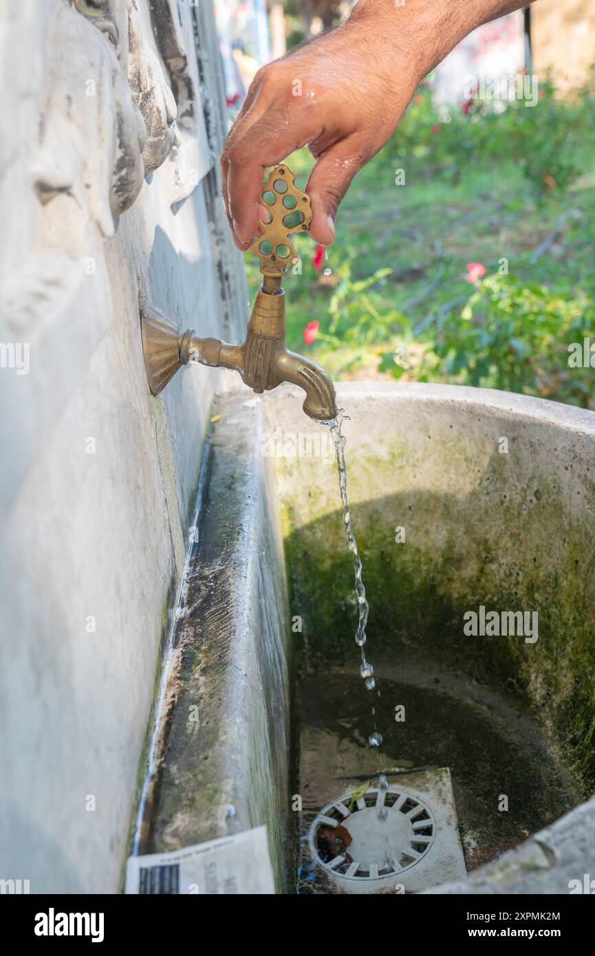 A hand opening a tap in a park Stock Photo - Alamy