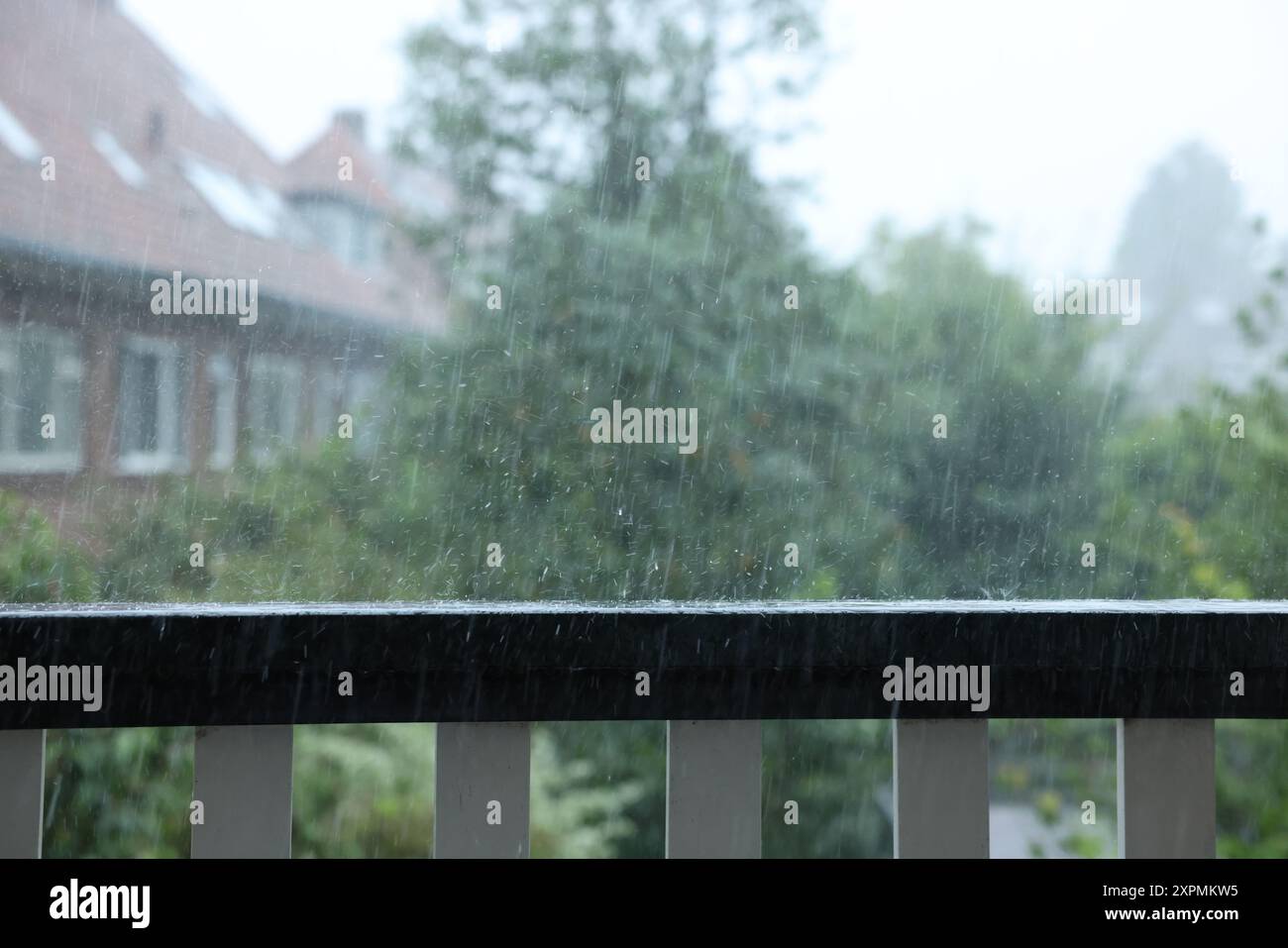 View on buildings and trees from balcony on rainy day Stock Photo - Alamy