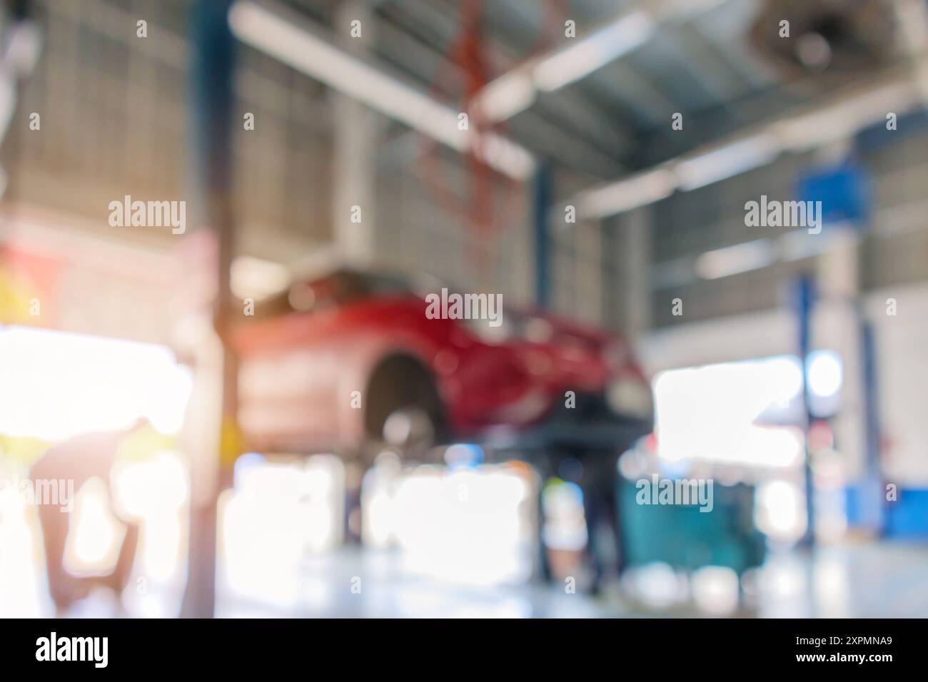 Red car lift at maintenance station in automotive service center blur ...