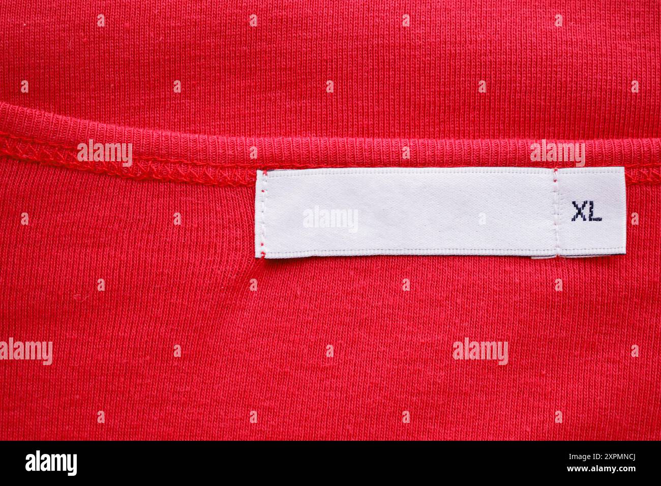Blank white clothes tag label with XL size on new red shirt Stock Photo ...