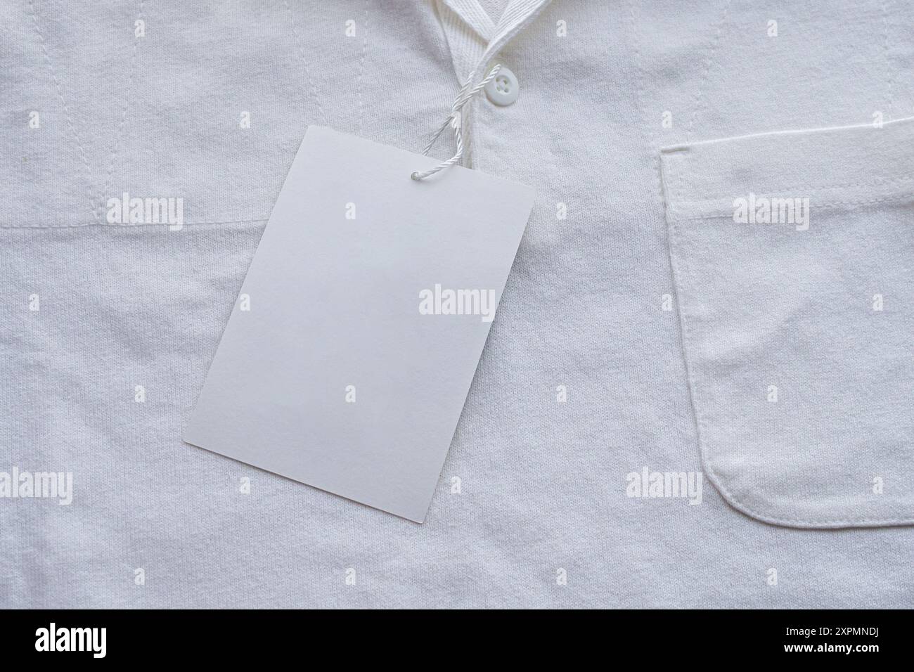 Blank white clothes tag label on new shirt Stock Photo - Alamy