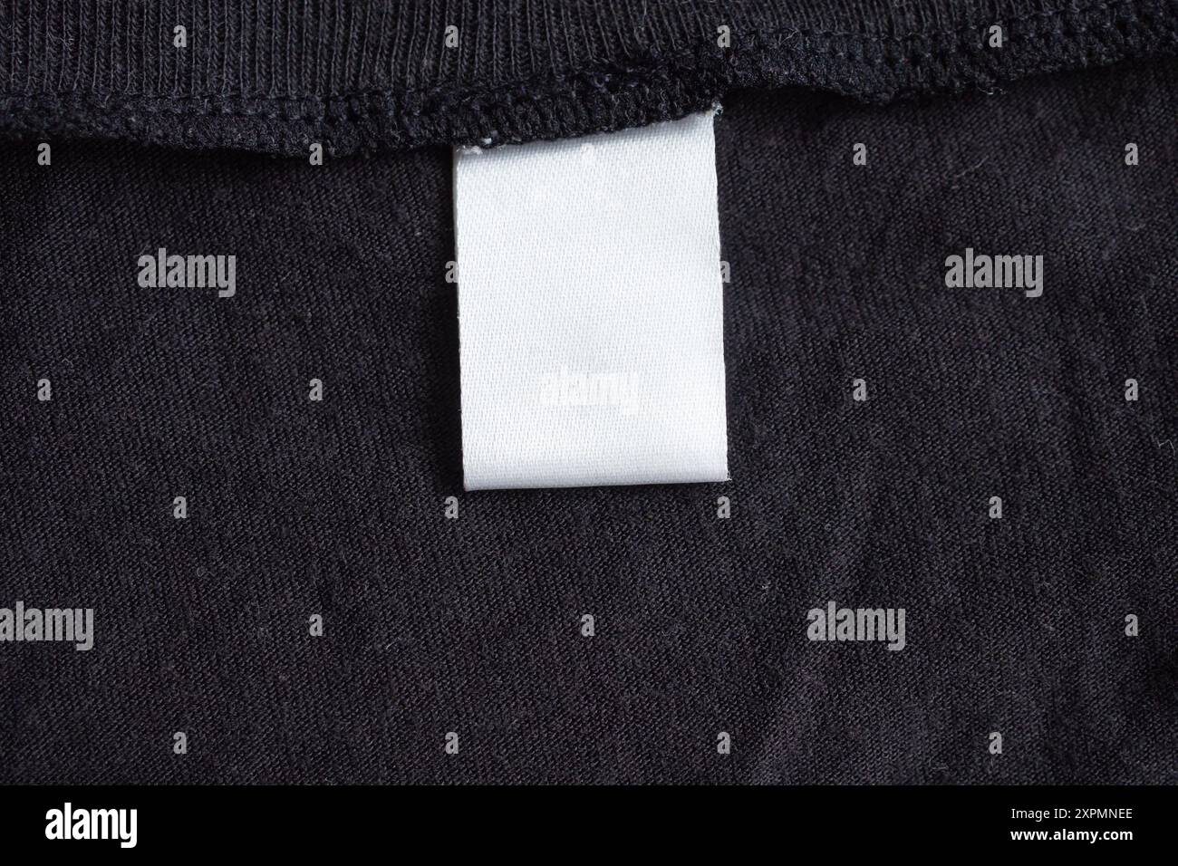 Blank white laundry care clothing label on black fabric texture Stock ...