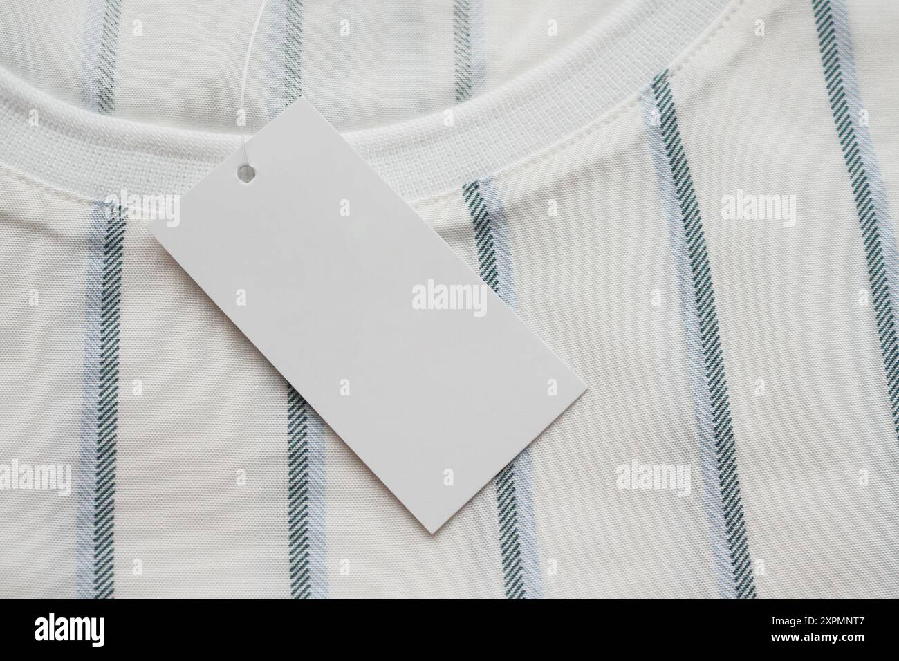Blank white clothes tag label on new shirt Stock Photo - Alamy