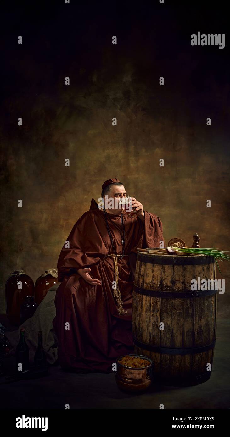 Medieval man, monk sitting in rustic monastery, drinking freshly brewed ...