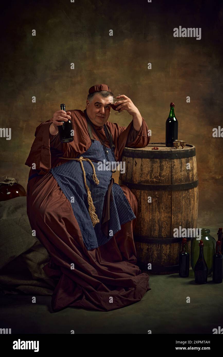 Hangover. Medieval man, monk in traditional attire leaning glass with ...