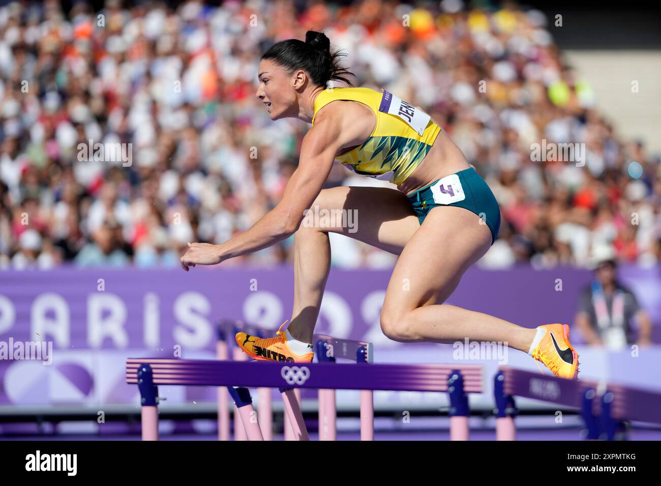 Michelle Jenneke, of Australia, knocks down a hurdle during a heat in ...
