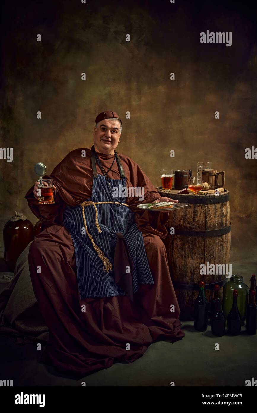 Medieval monk, holding pint of ale and plate of food, with wooden ...