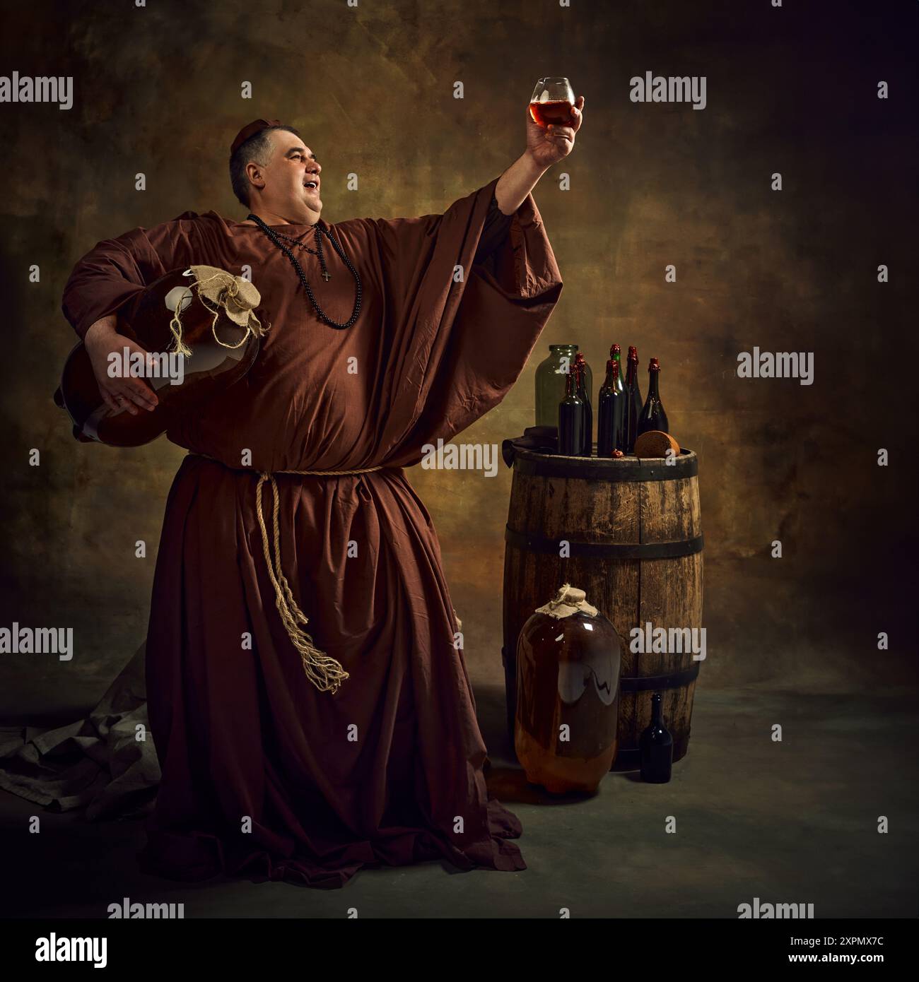 Proud man, medieval monk raising glass of ale, or cognac against ...