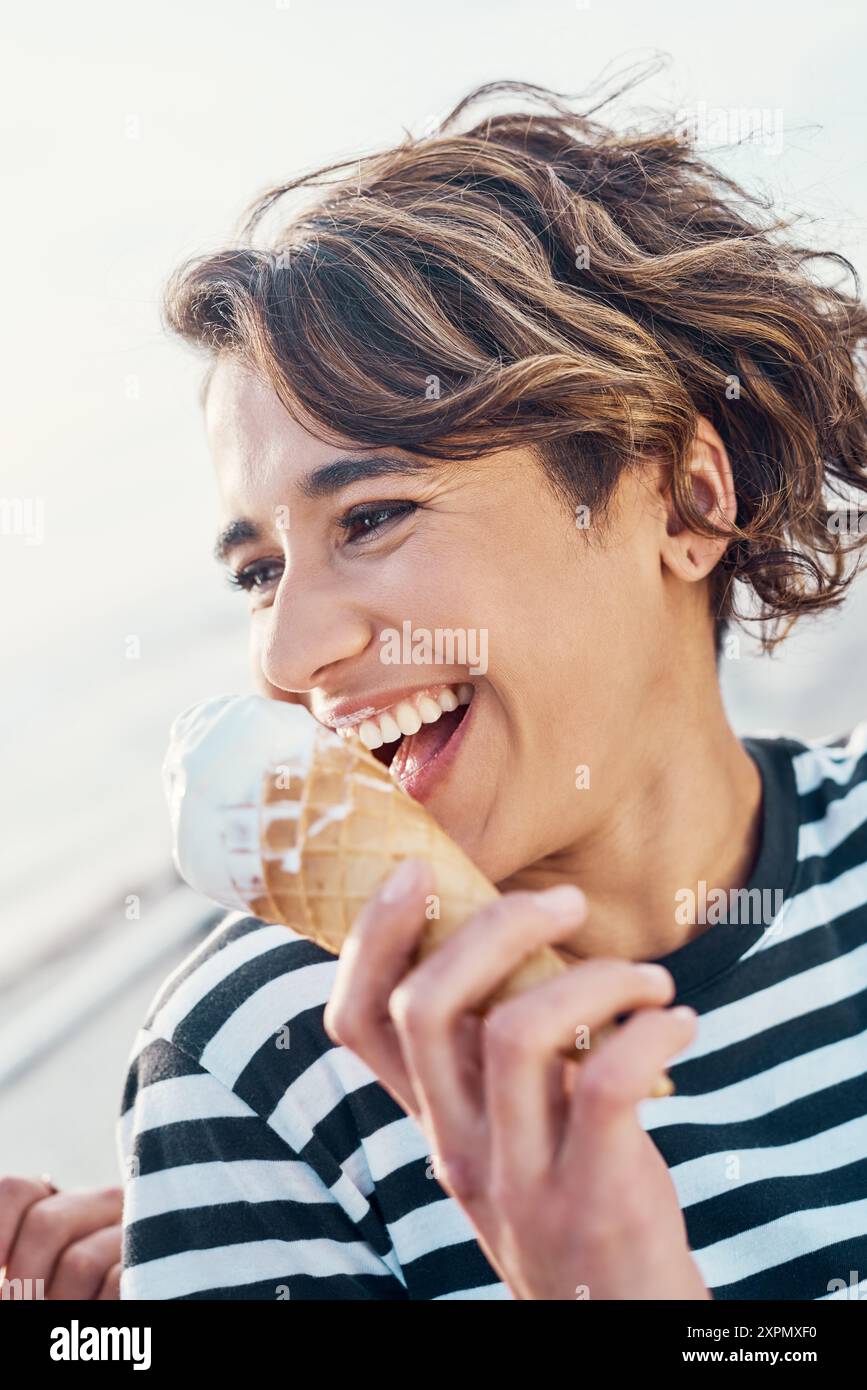 Woman, laughing and eating an ice cream outdoor for summer dessert ...