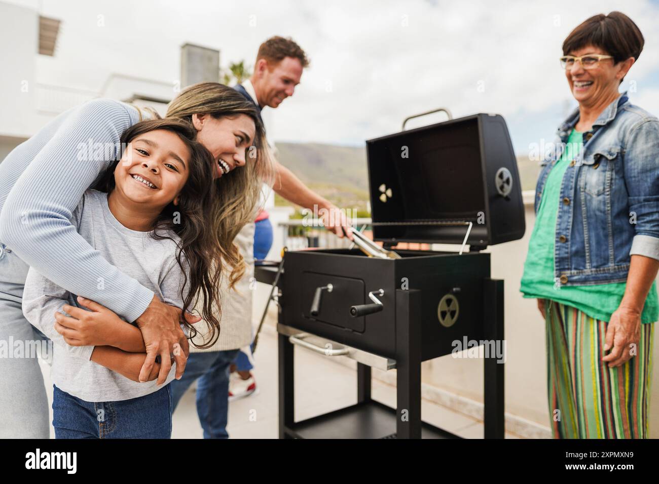 Happy family doing barbecue together hi-res stock photography and ...