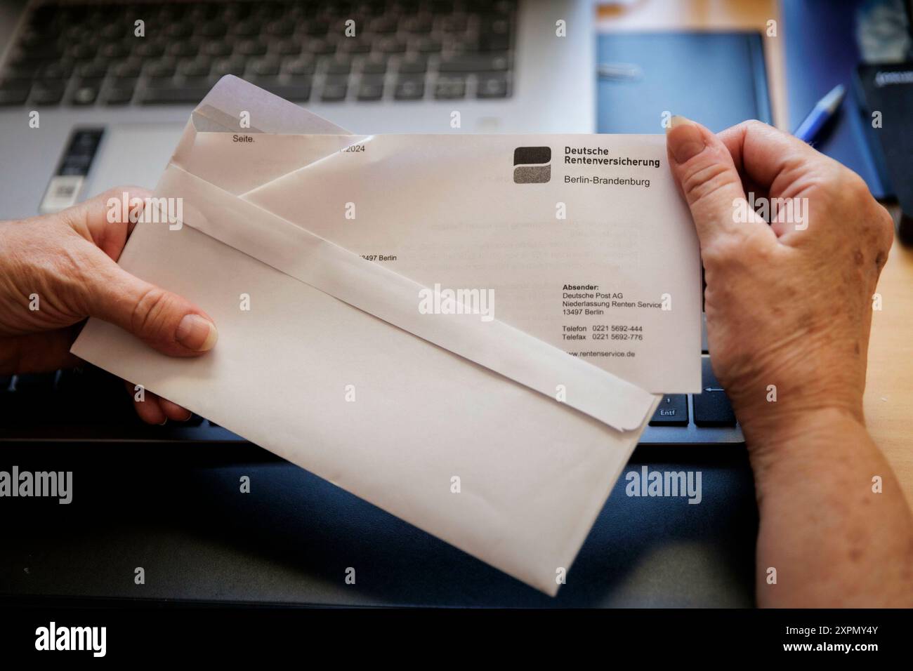 Berlin, Deutschland. 05th Aug, 2024. An elderly woman opens a letter ...