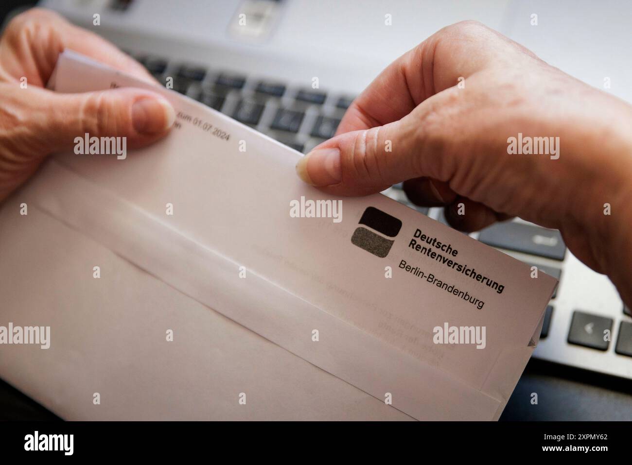 Berlin, Deutschland. 05th Aug, 2024. An elderly woman opens a letter ...