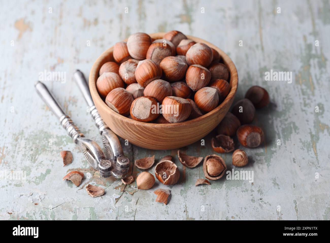 Wooden plate full of hazelnuts with silver nutcracker. Food photography ...