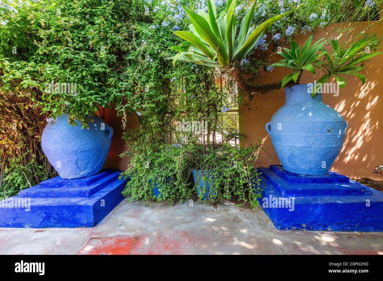 Two large light blue flower pots stand guard at the edge of a small ...
